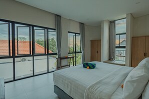 Quarto de hotel moderno com uma cama grande, vista para a cidade e uma varanda.