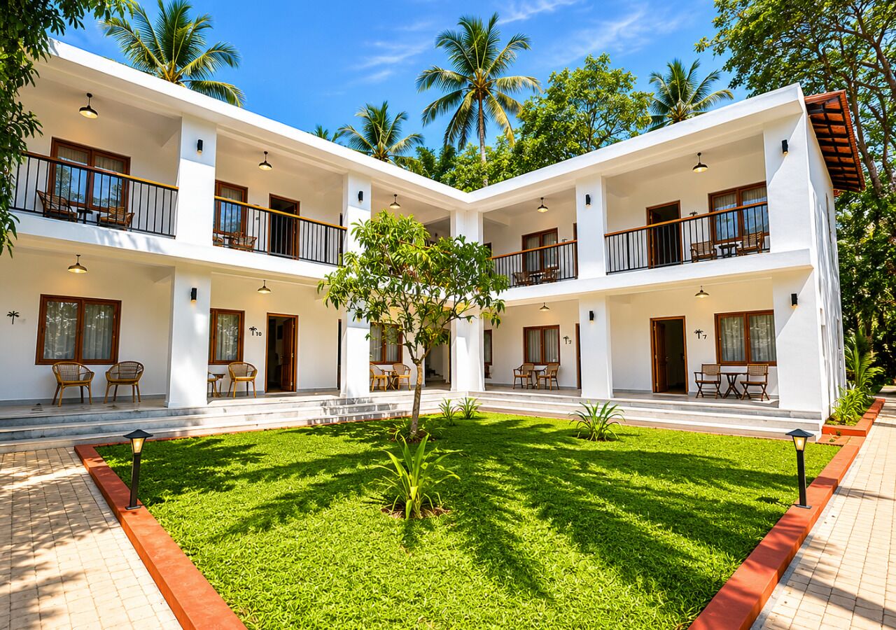 Hotel com vários andares, varandas, área de estar ao ar livre e um jardim central.