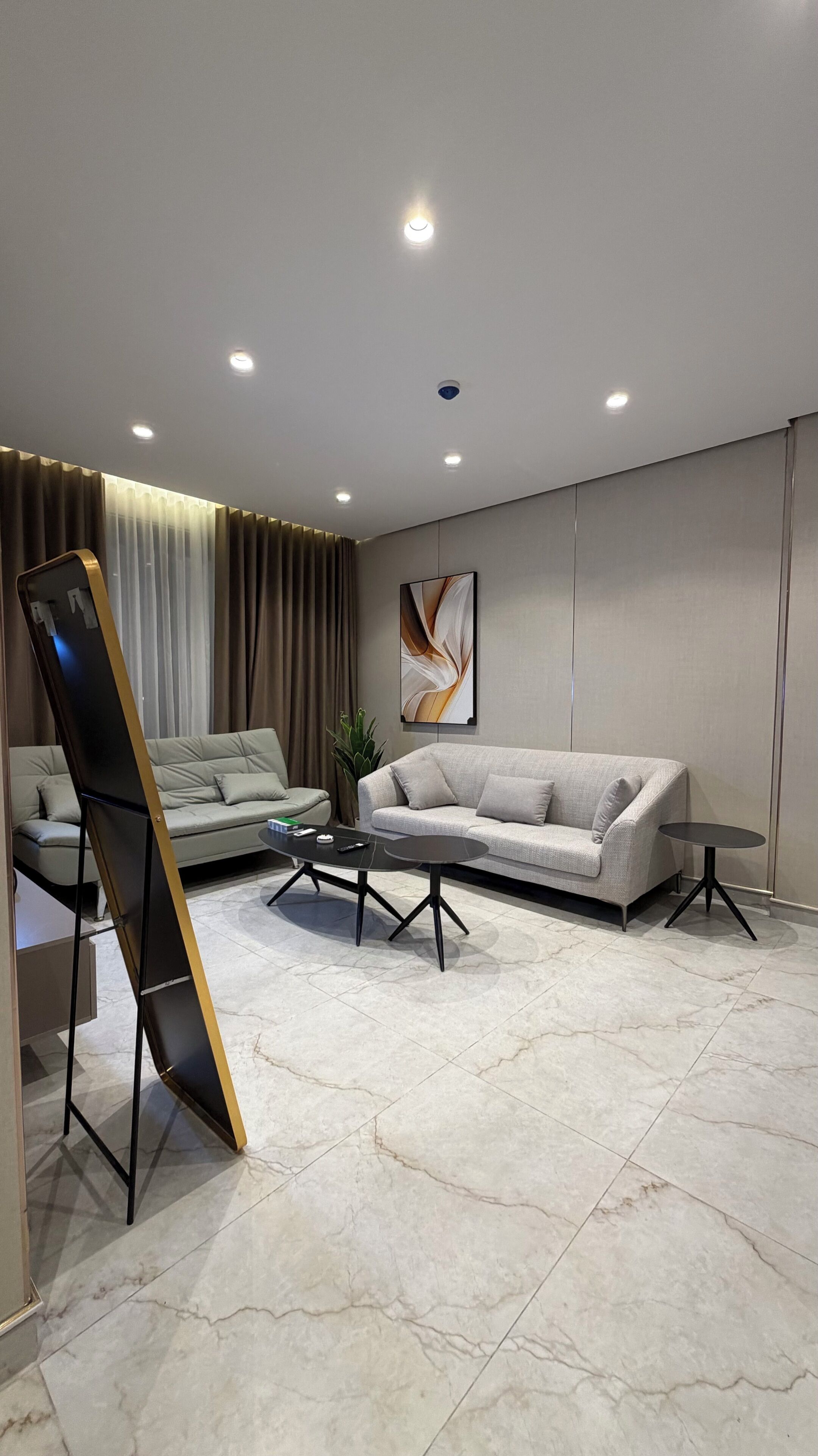 Uma sala de estar moderna com um sofá, uma mesa de centro e um quadro na parede.