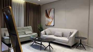 Uma sala de estar moderna com um sofá, uma mesa de centro e um quadro na parede.