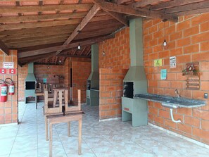 Um edifício de tijolos com piso de azulejos, móveis de madeira e um forno de barro.