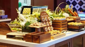 Disposição de buffet com diversos alimentos e um aviso indicando 'All you need is Brown & Beans'.