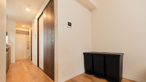 Um corredor com piso de madeira, um console preto e uma porta que dá para outro quarto.