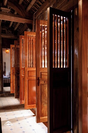 Um corredor com portas de madeira e chão de azulejos.