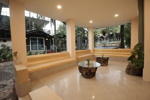 Um espaço amplo e interno com área de estar, escada e vista para o exterior.