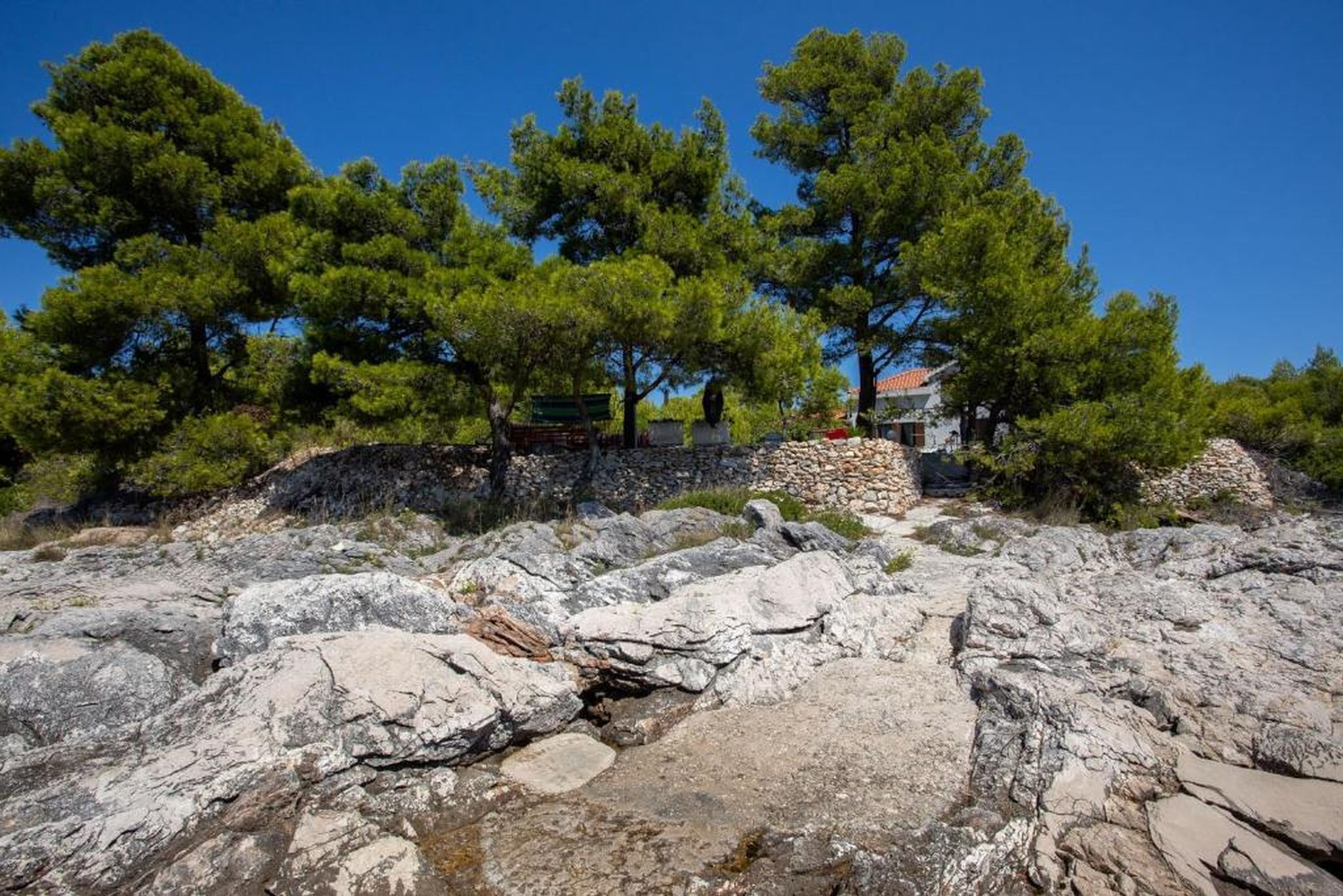Paisagem rochosa com árvores e uma construção de pedra.