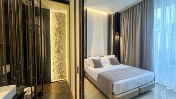 Quarto de hotel moderno com uma cama grande, um closet espaçoso e vista para o exterior.
