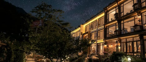 Um hotel com céu estrelado, área de estar ao ar livre e um jardim bem iluminado.