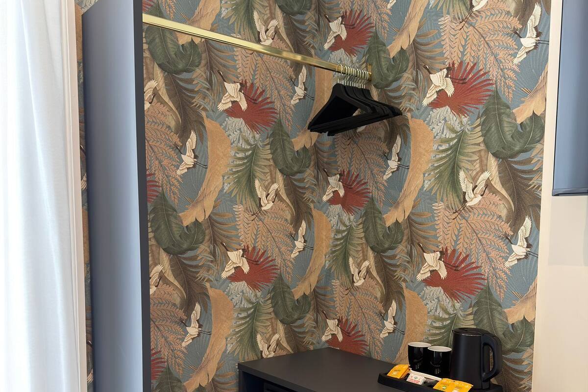 Quarto compacto com cama, escrivaninha e armário.