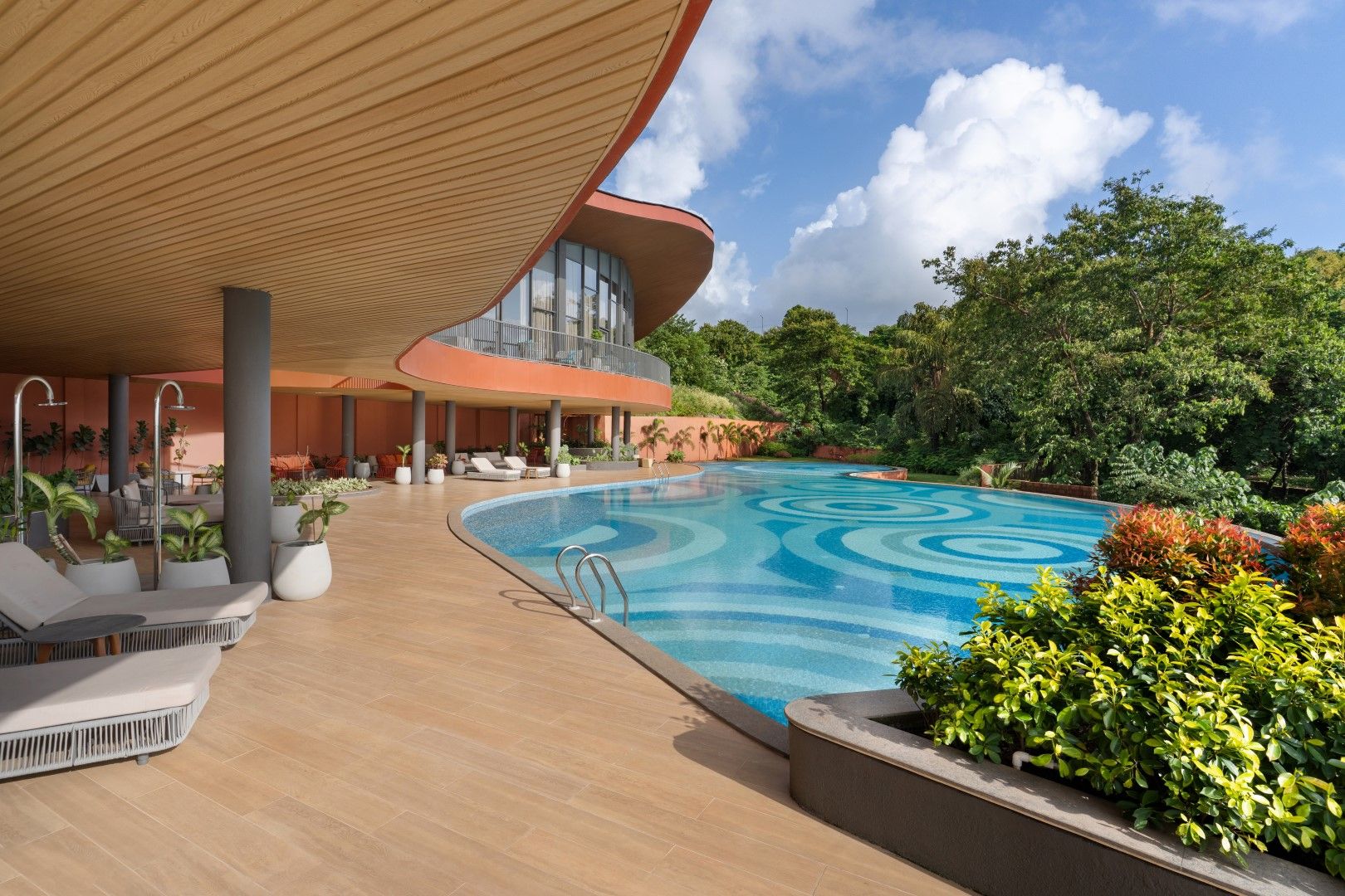 Uma área de piscina moderna com design arquitetônico único, incluindo um teto curvo e uma piscina com padrão azul e branco.