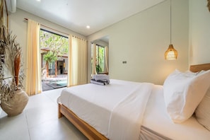 Quarto com cama, planta em vaso e vista para o exterior.