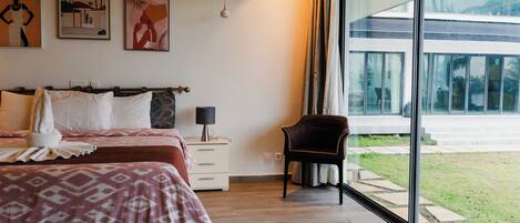 Quarto com cama grande, uma cadeira, mesa de cabeceira e obras de arte na parede.