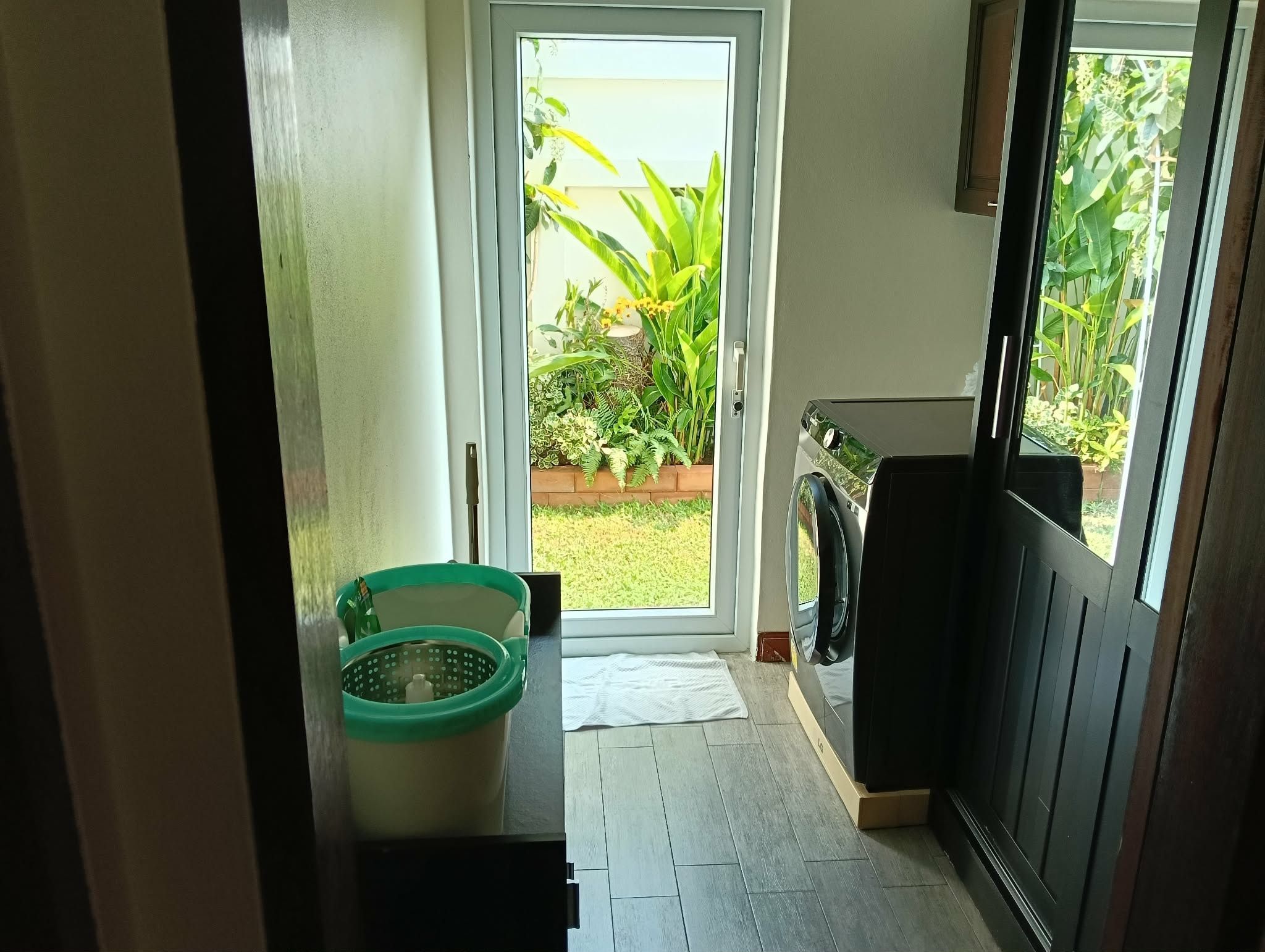 Corredor que leva a uma porta com vista para um jardim.