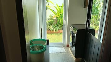 Corredor que leva a uma porta com vista para um jardim.