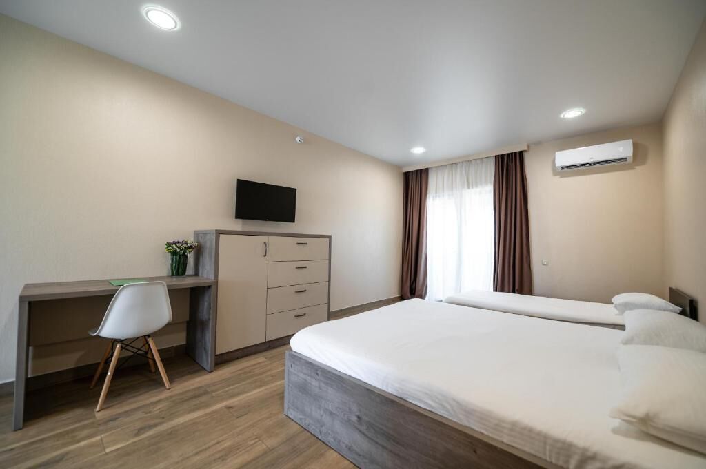 Quarto Quádruplo Deluxe, varanda, vista para o mar | Sala de estar | TV de ecrã plano 