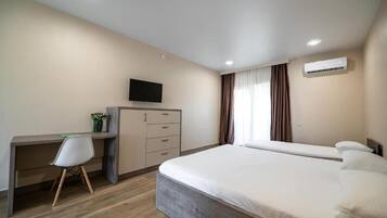 Quarto Quádruplo Deluxe, varanda, vista para o mar | Sala de estar | TV de ecrã plano