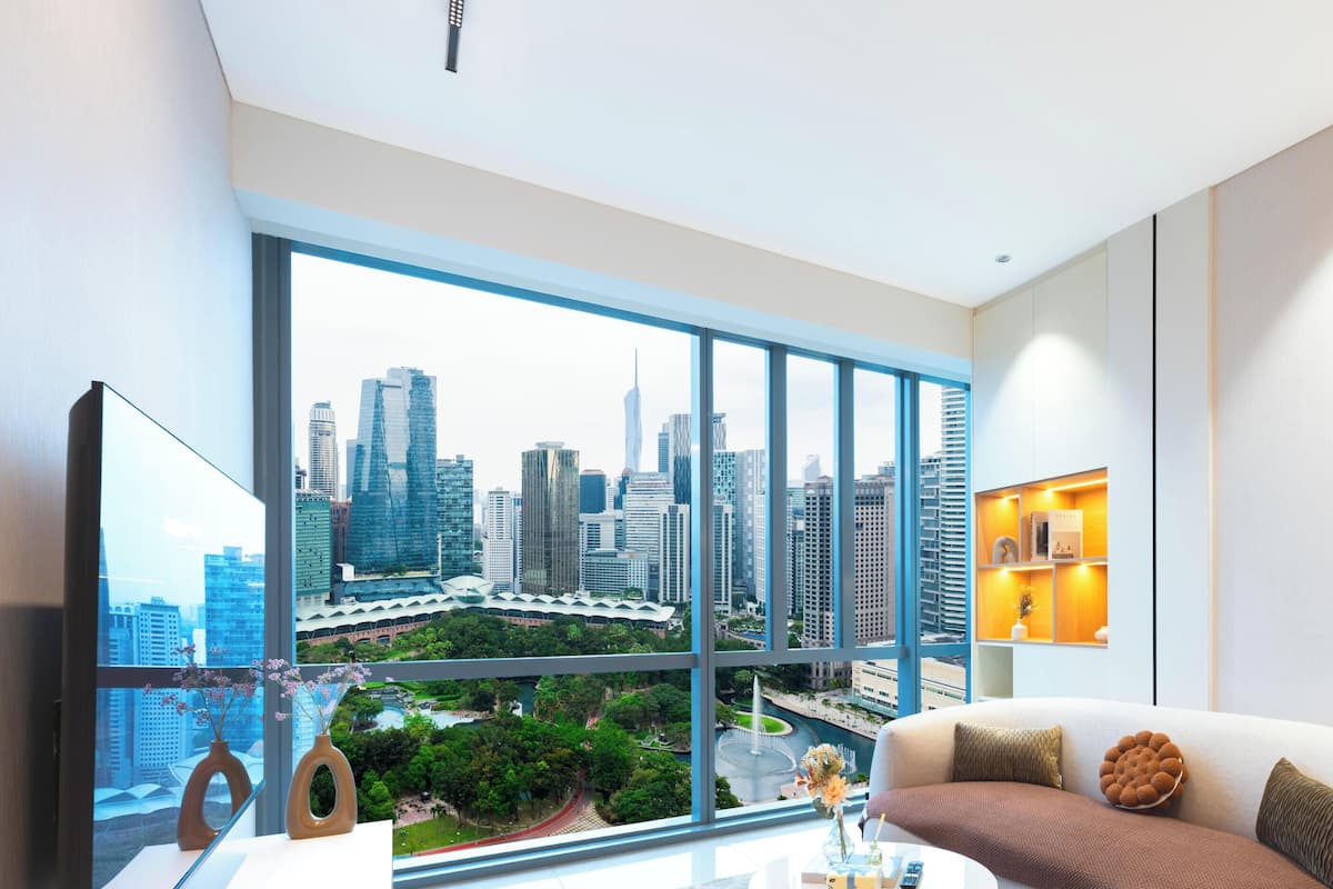 Uma sala de estar moderna com uma grande janela, um sofá, uma televisão de tela plana e vista para a cidade.