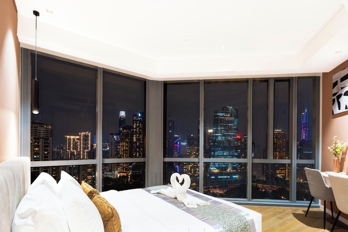 Quarto de hotel com vista para a cidade, uma cama, uma escrivaninha e uma cadeira.