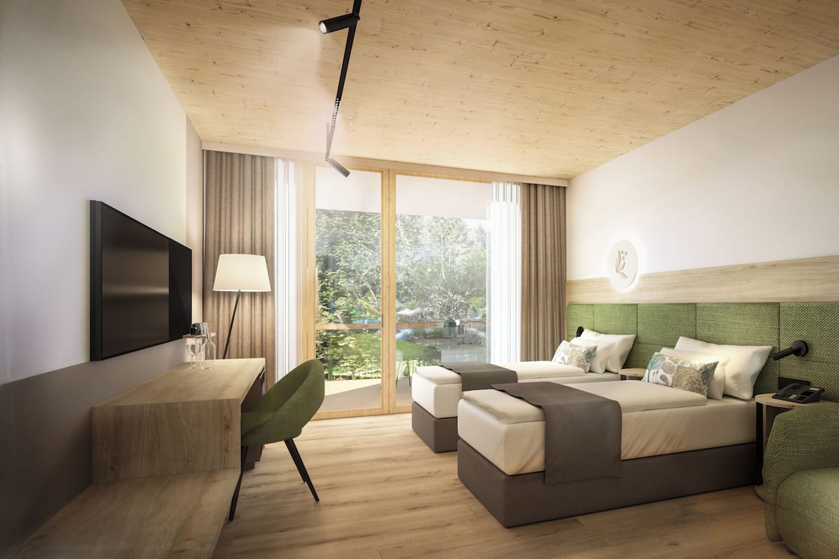 Um quarto moderno com uma cama, duas mesas de cabeceira, uma escrivaninha e uma cadeira.