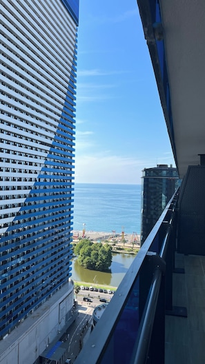 Um edifício alto com vista para o mar e uma área de praia abaixo.