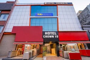 Fachada de hotel com uma placa indicando 'HOTEL CROWN 15' e a marca 'fabHOTELS'.