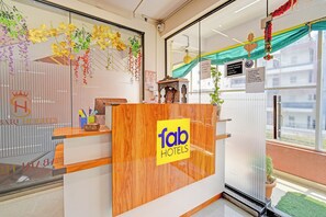 Uma receção com um logotipo, sinal de checkout e vista para a janela.