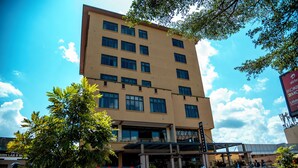 Um edifício de vários andares com fachada plana, janelas amplas e área de entrada coberta.