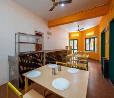 Restaurante com mesas e cadeiras de madeira e um ventilador de teto.