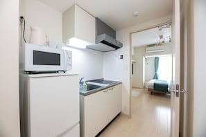 Uma cozinha compacta com micro-ondas, fogão e armários.