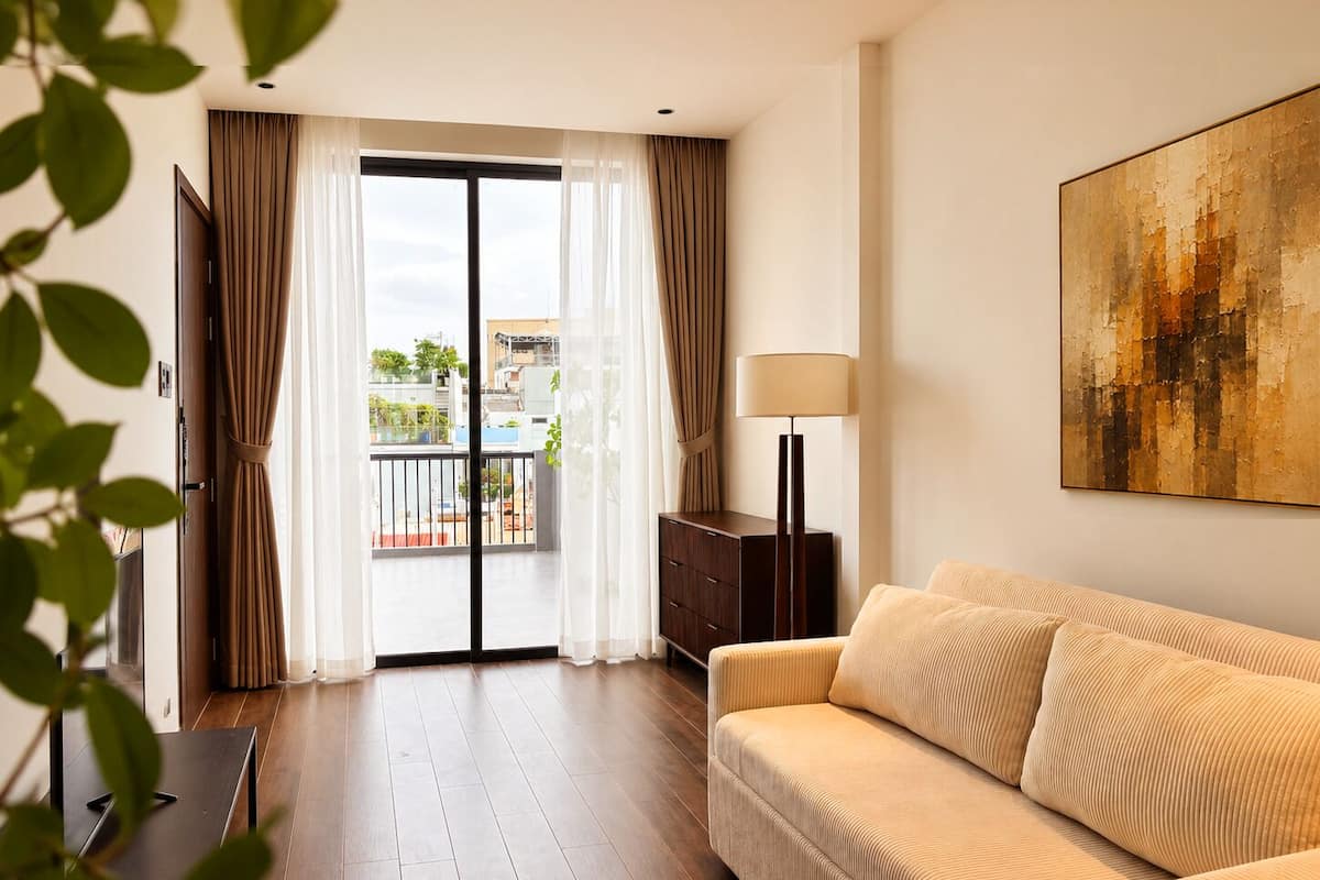 Sala de estar moderna com sofá, luminária, pintura e vista por uma porta deslizante.