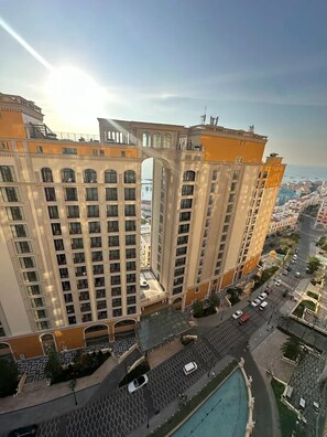 Um edifício alto com vários andares, um pátio central e uma piscina.