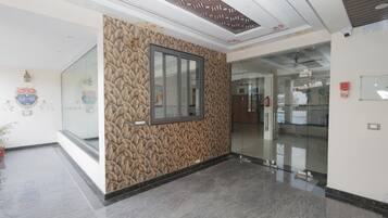 Um interior moderno com parede estampada, porta de vidro e teto com design geométrico.