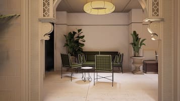 Um hall com um sofá verde, duas cadeiras, uma mesa e plantas em vasos.
