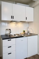 Apartamento | Cozinha privada | Frigobar, micro-ondas em uma área comum, cooktop