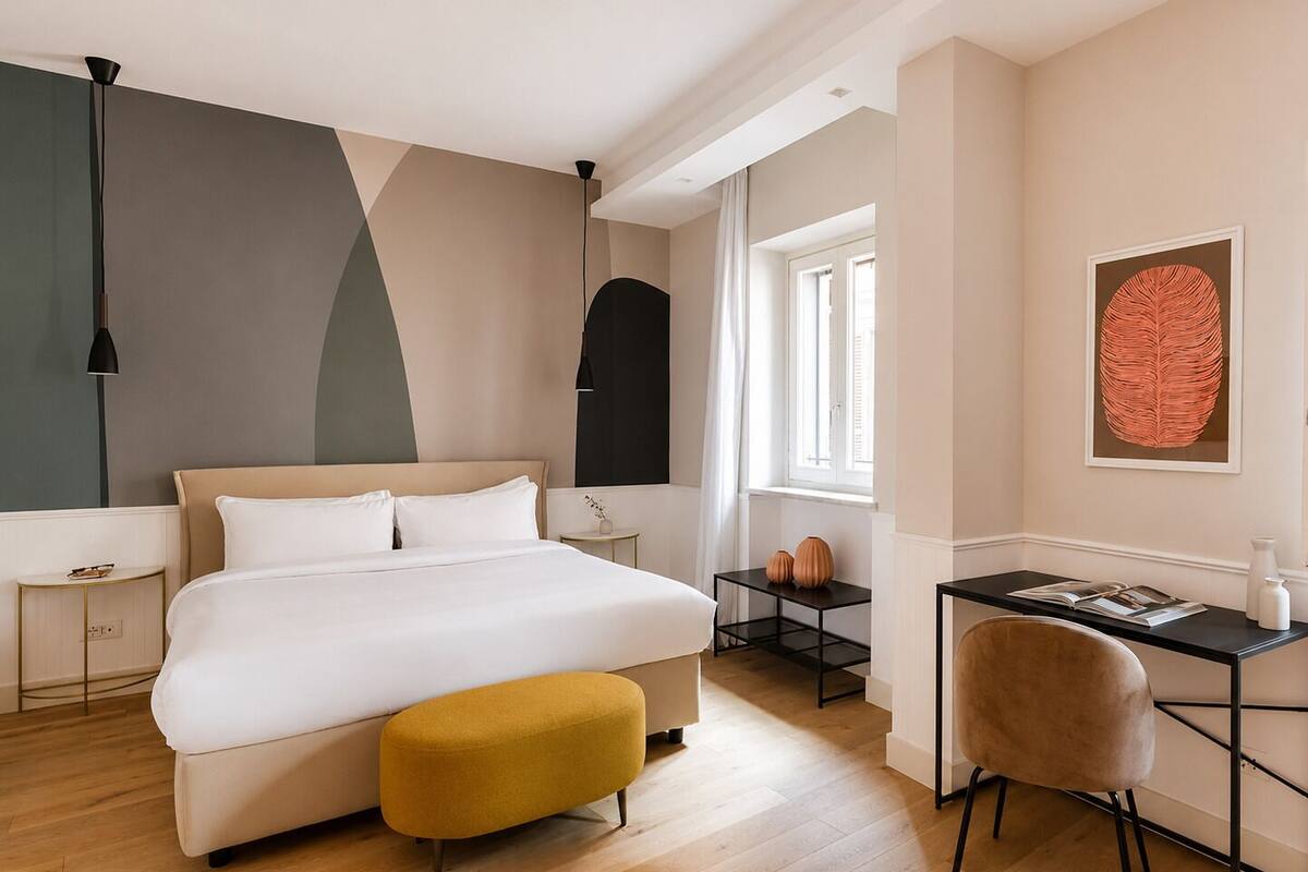 Quarto moderno com cama, mesa de cabeceira pequena, escrivaninha com cadeira e janela.