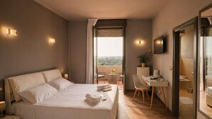 Quarto de hotel moderno com uma cama grande, uma escrivaninha, uma cadeira e vista para o exterior.