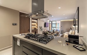 Uma cozinha moderna com uma ilha central, forno embutido e um exaustor grande.