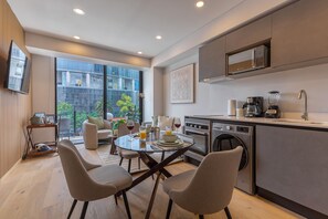 Uma cozinha moderna com área de jantar, janelas amplas e vista para a cidade.