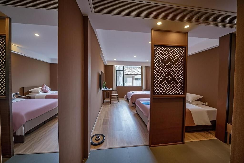Quarto de hotel com duas camas, uma escrivaninha e vista para a cidade.