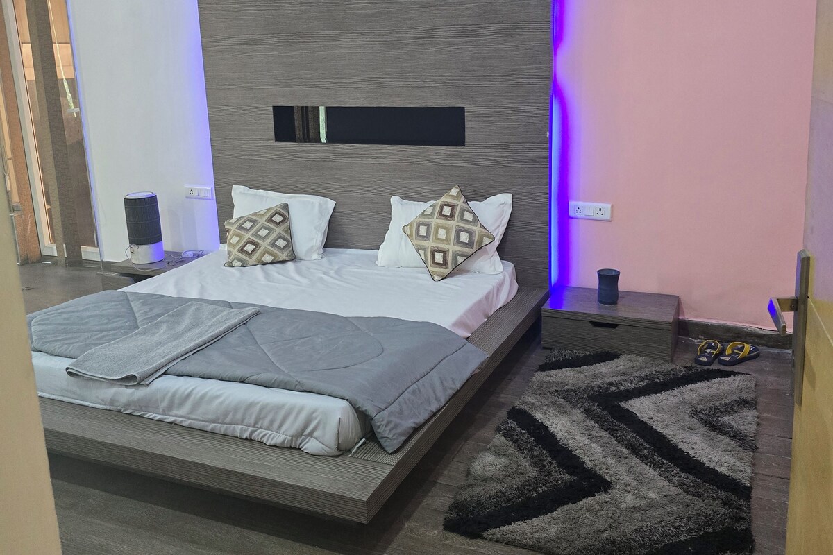 Quarto moderno com uma cama, ventoinha no teto, mesa de cabeceira e um tapete.