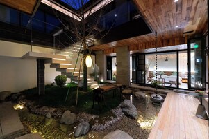 Um interior moderno com escada, área de estar e vista para o exterior.