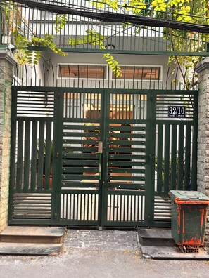 Uma entrada com portão e uma placa com a inscrição '32/10 ME LINH'.