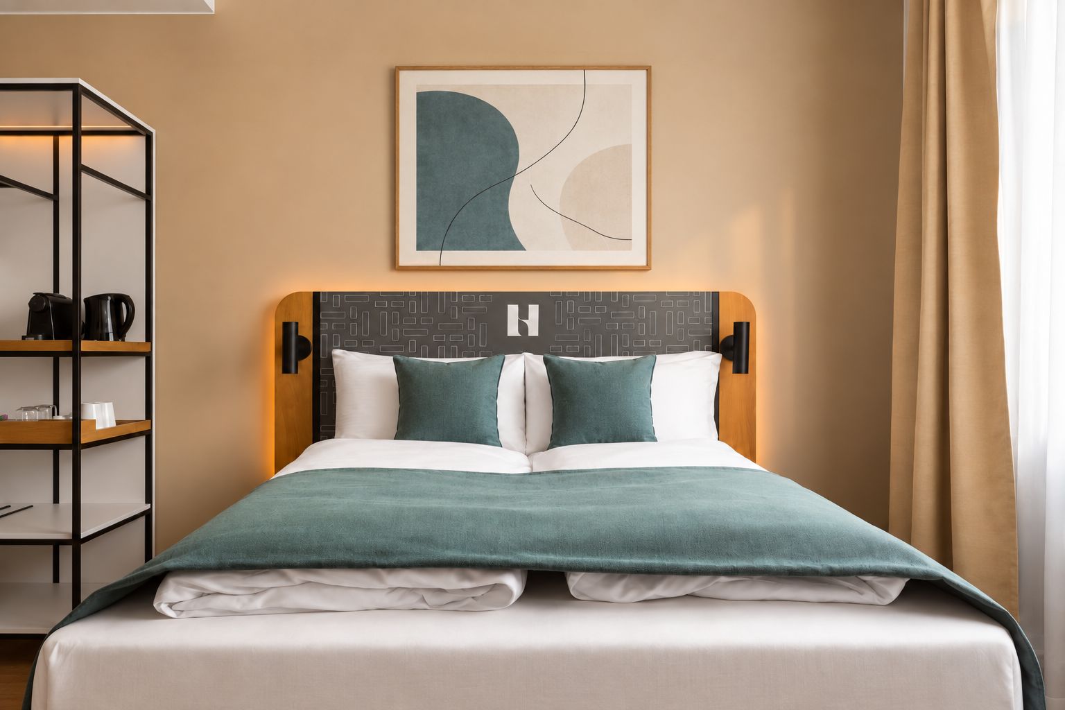 Uma cama bem arrumada com um cobertor verde, uma cabeceira com a letra 'H' e um quadro abstrato pendurado na parede.