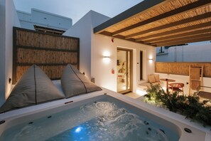 Uma área de spa com hidromassagem, assentos e uma parede de madeira.