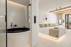 Uma casa de banho moderna com uma banheira independente e um espelho grande.