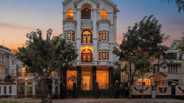 Um edifício de vários andares com fachada simétrica, grandes janelas e uma entrada central.