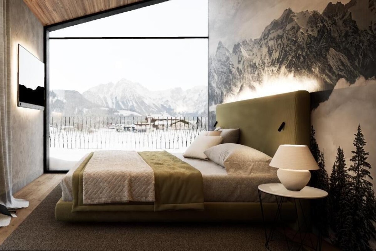 Um quarto com cama, mesa de cabeceira, luminária e vista para as montanhas.