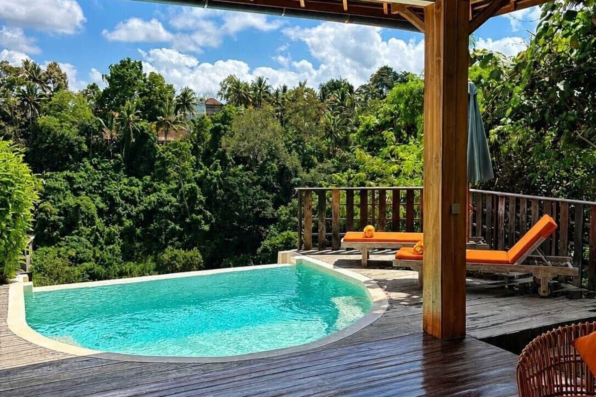 Uma área de piscina com espreguiçadeiras e móveis de vime.