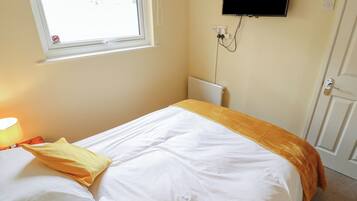 Quarto com cama, janela, televisão na parede e porta.