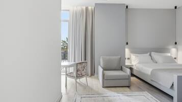 Quarto de hotel moderno com uma cama grande, uma cadeira, uma mesa de cabeceira e vista para o exterior.